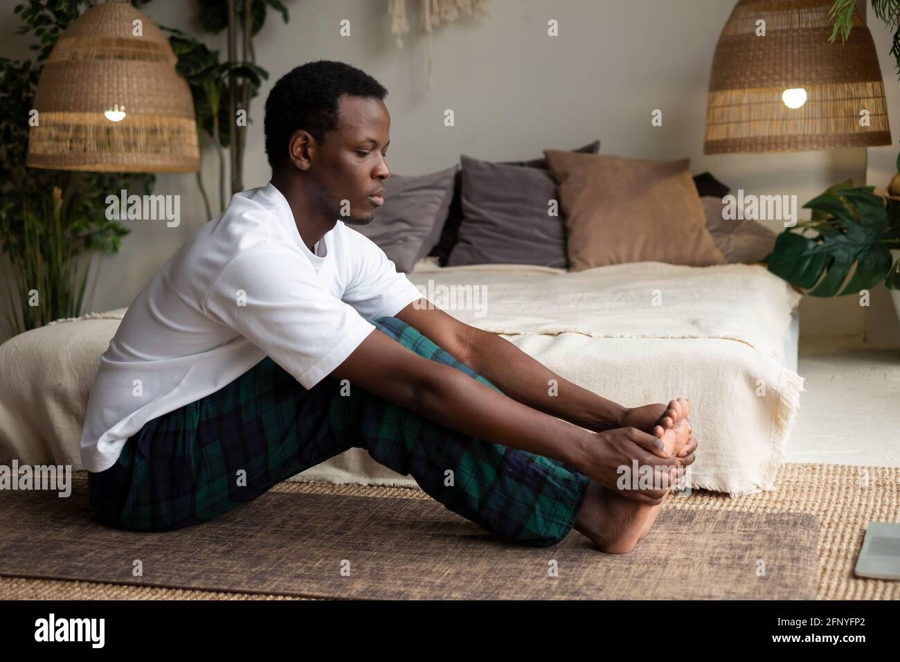 African young man sitting in paschimottanasana or Intense Dorsal ...