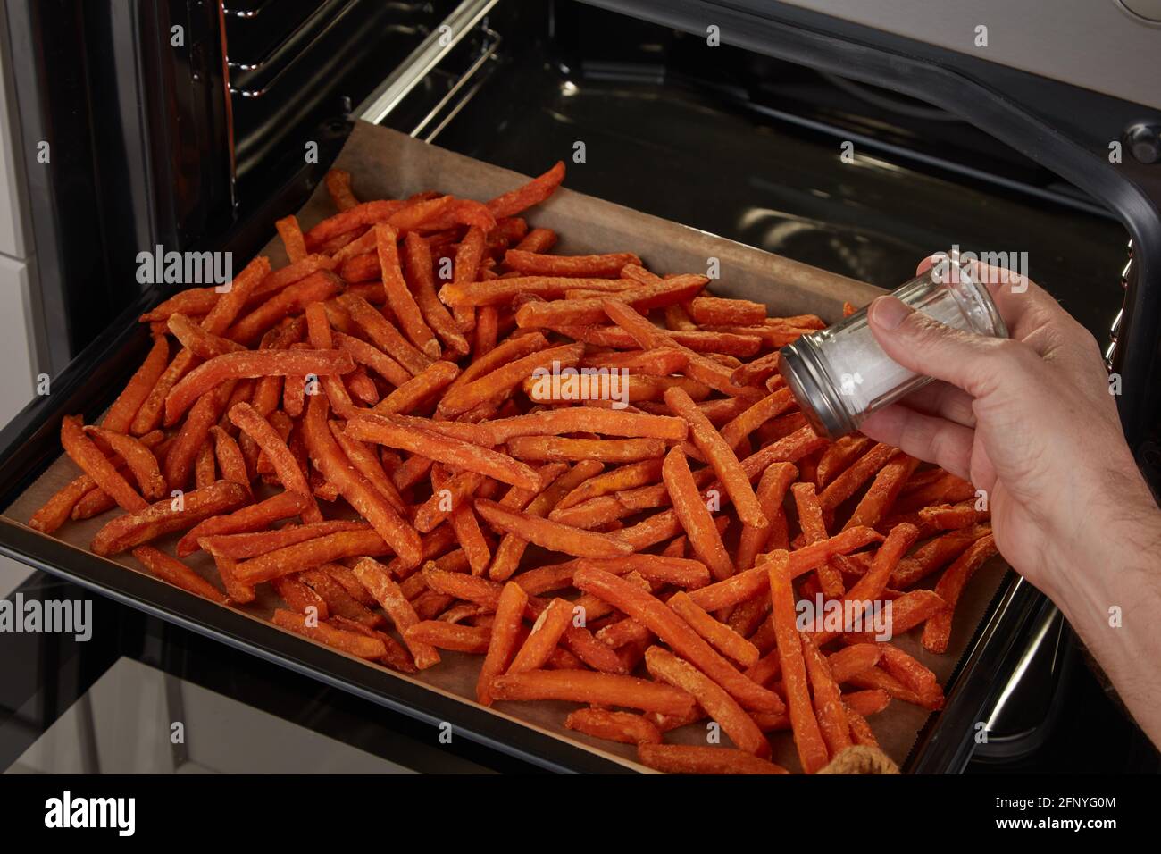 From above anonymous person adding salt to fresh vegetable fries on ...