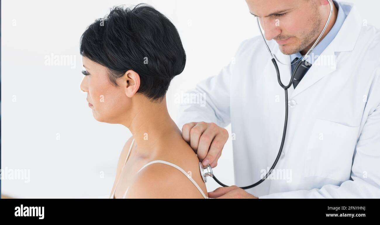 Caucasian female doctor wearing stethoscope examining back of female ...