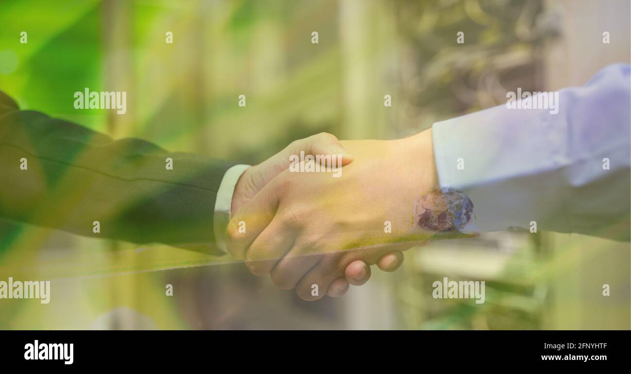 Digital composite image of trees against mid section of two businessmen ...