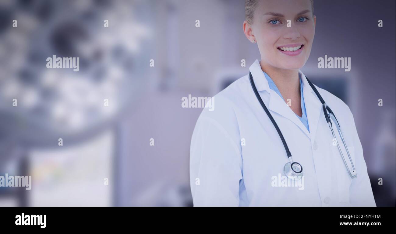 Portrait of caucasian female doctor smiling against surgical light in ...