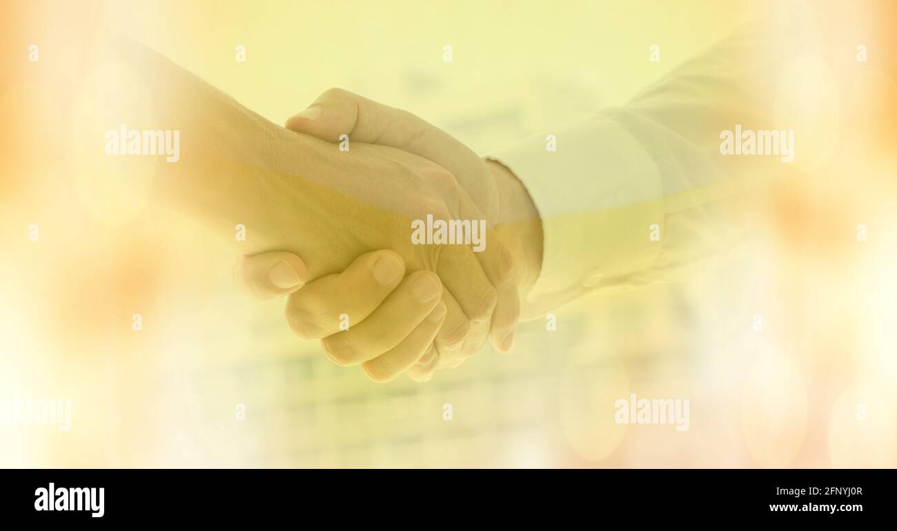Composition of businessman handshake with glowing yellow spots of light ...