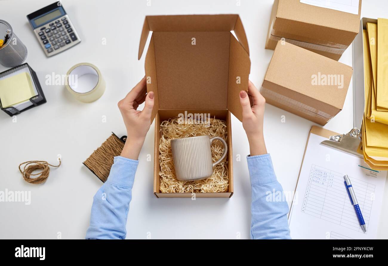 hands packing mug to parcel box at post office Stock Photo - Alamy