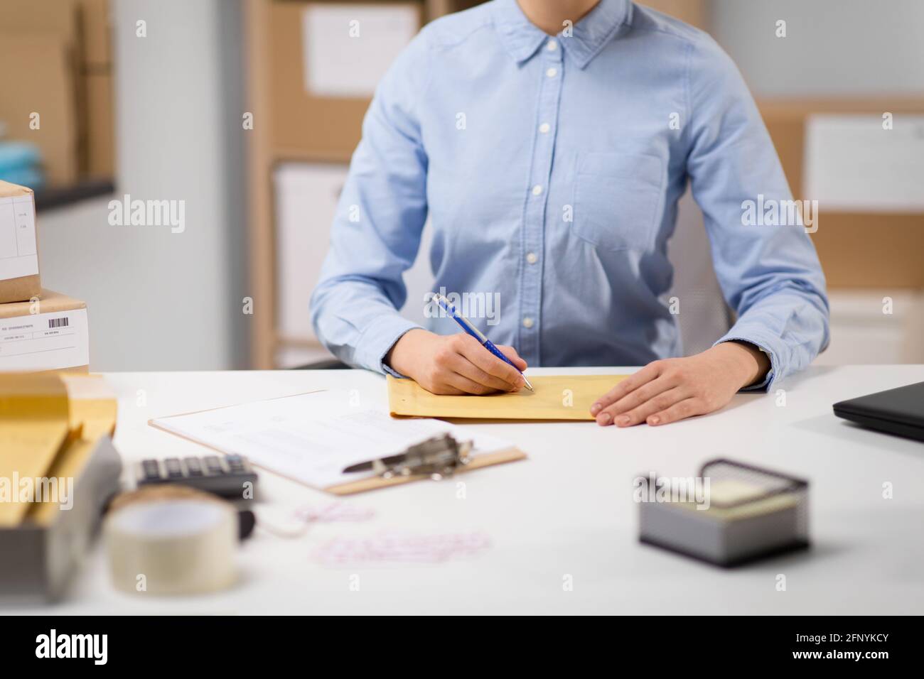 woman writing on parcel envelope at post office Stock Photo - Alamy