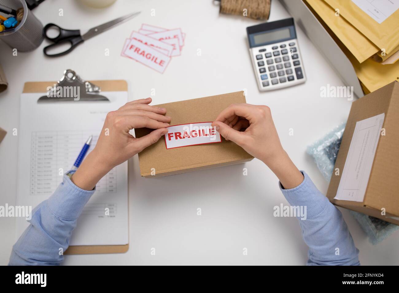 woman sticking fragile mark to parcel box Stock Photo - Alamy