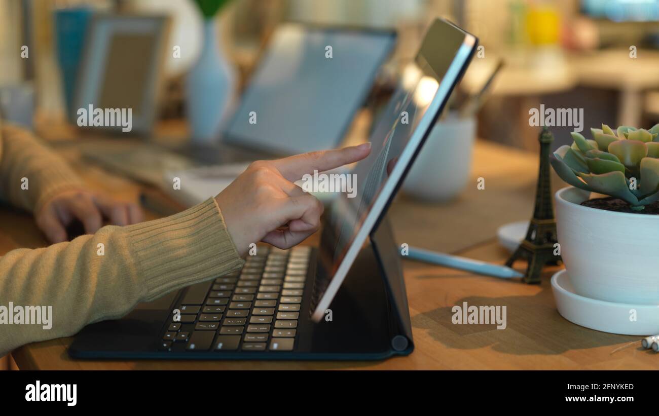Side view of female finger pointing on laptop screen in office room ...