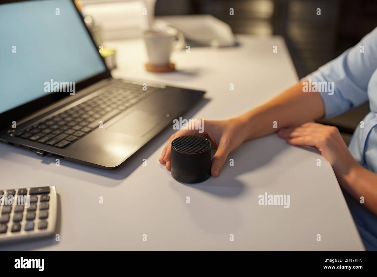 hand using smart speaker at night office Stock Photo - Alamy