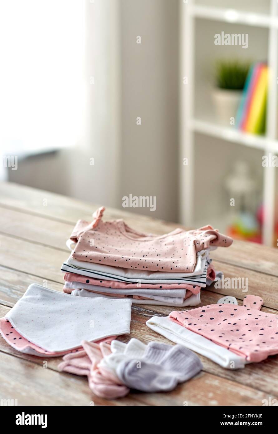 baby clothes on wooden table at home Stock Photo - Alamy