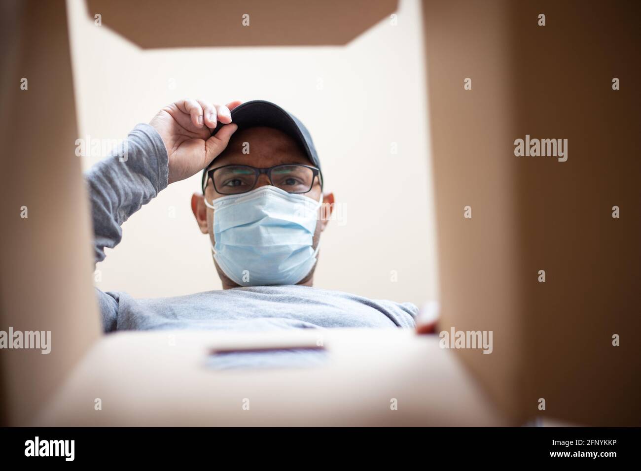 Man face mask opening cardboard hi-res stock photography and images - Alamy
