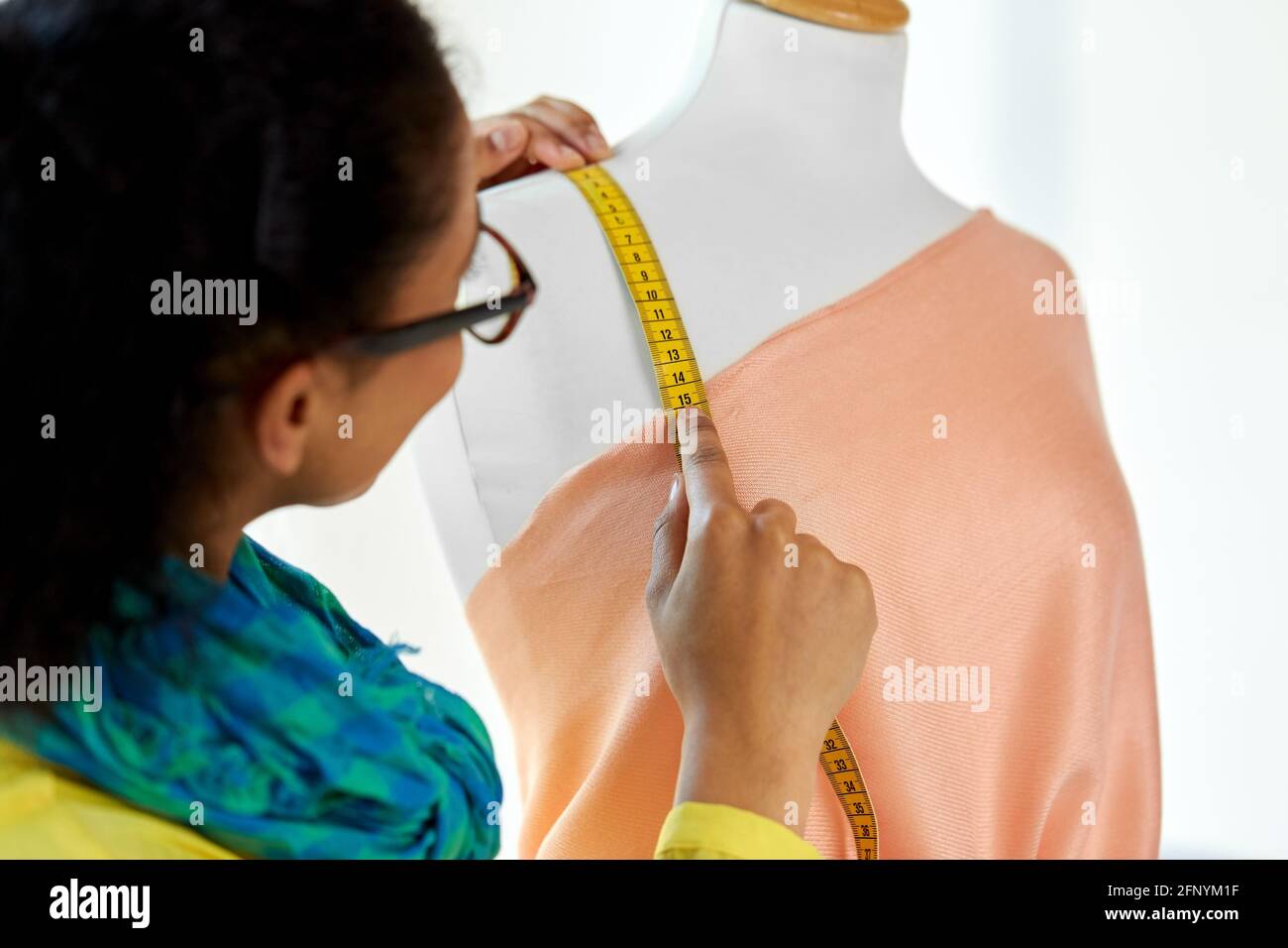fashion designer measuring dress with tape measure Stock Photo - Alamy