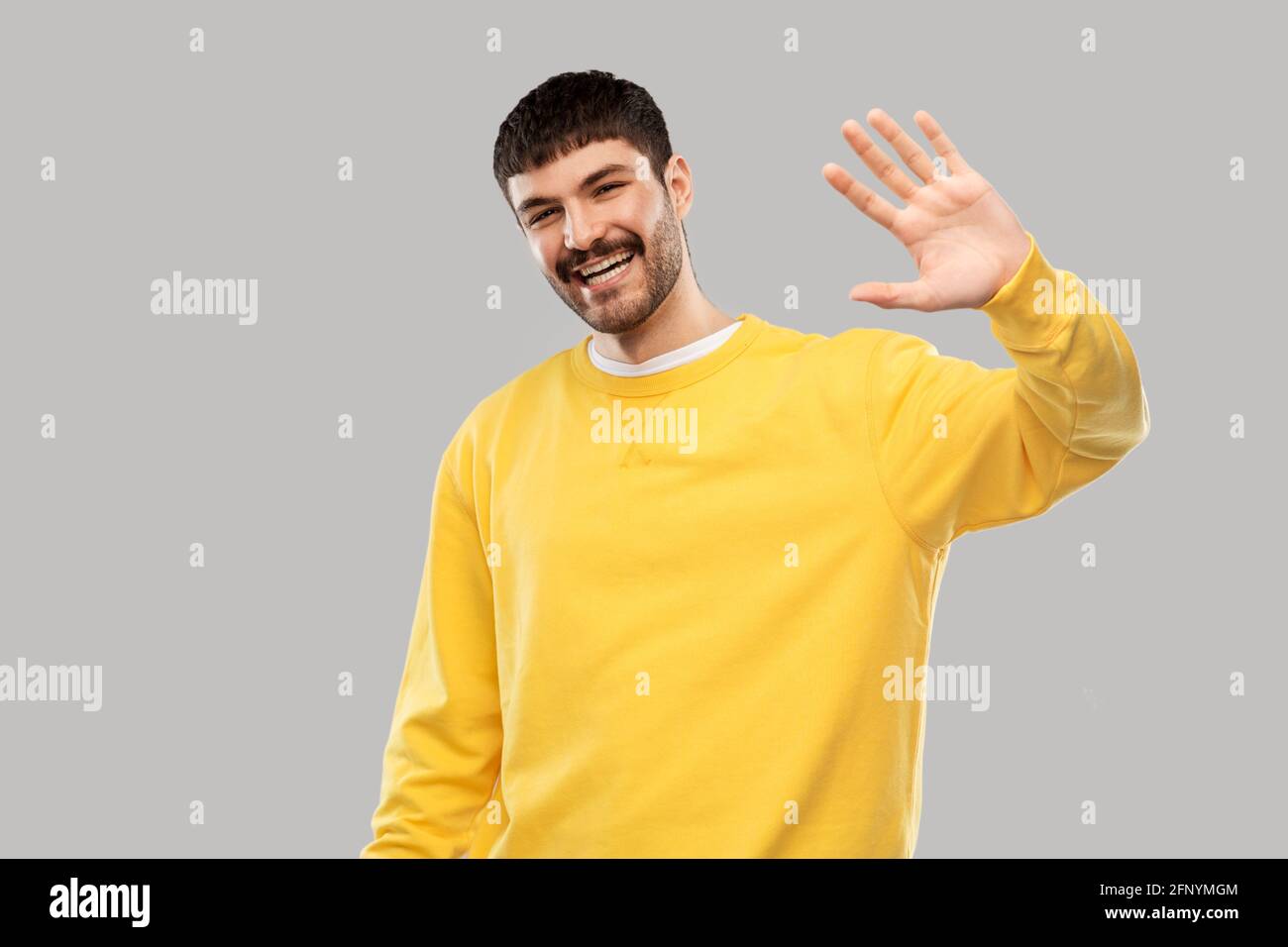 Smiling young man waving hi-res stock photography and images - Alamy