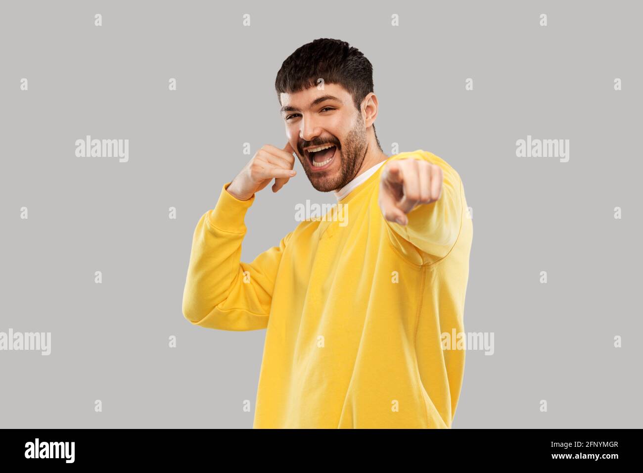 man making phone call gesture and pointing finger Stock Photo - Alamy