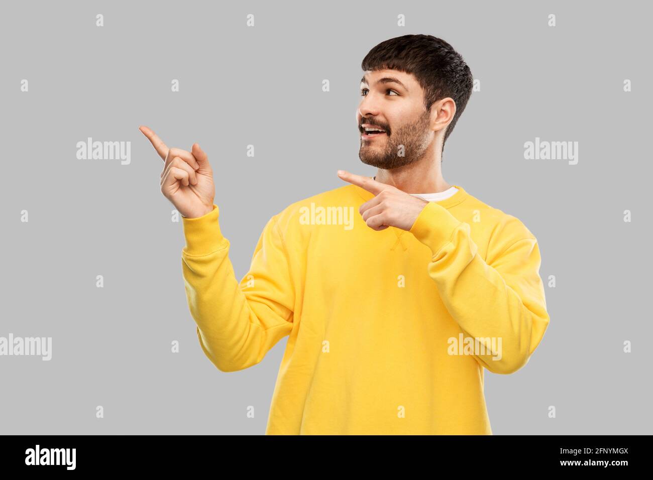 smiling man pointing fingers to something Stock Photo - Alamy