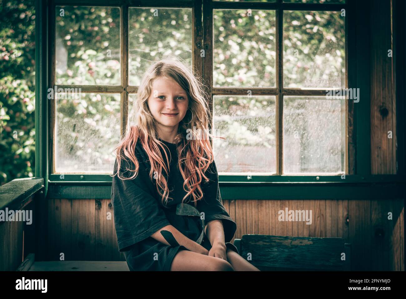 beautiful blond smiling girl sitting by the window, magic pastel tone ...