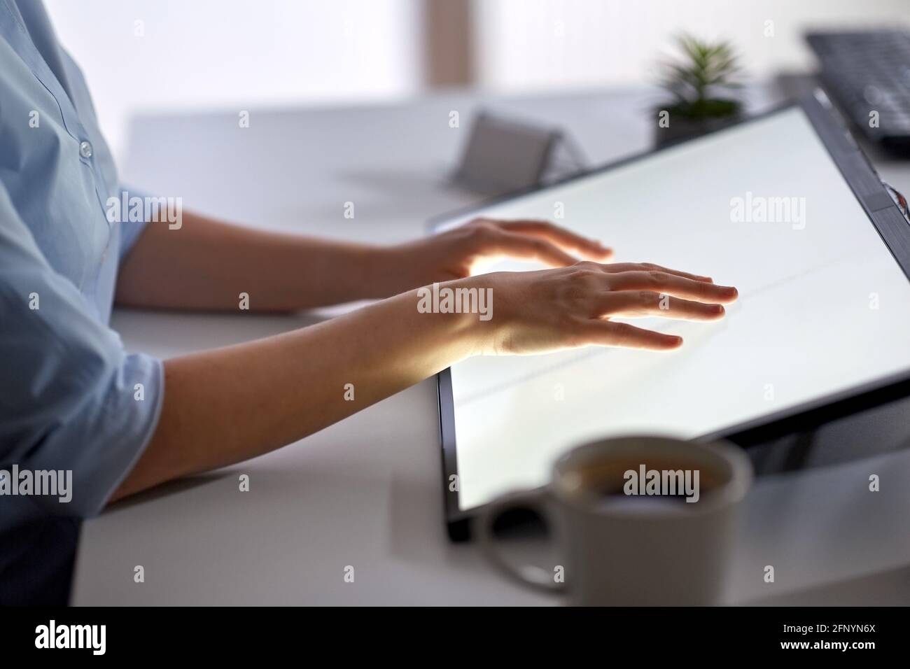 hands on led light tablet at night office Stock Photo - Alamy