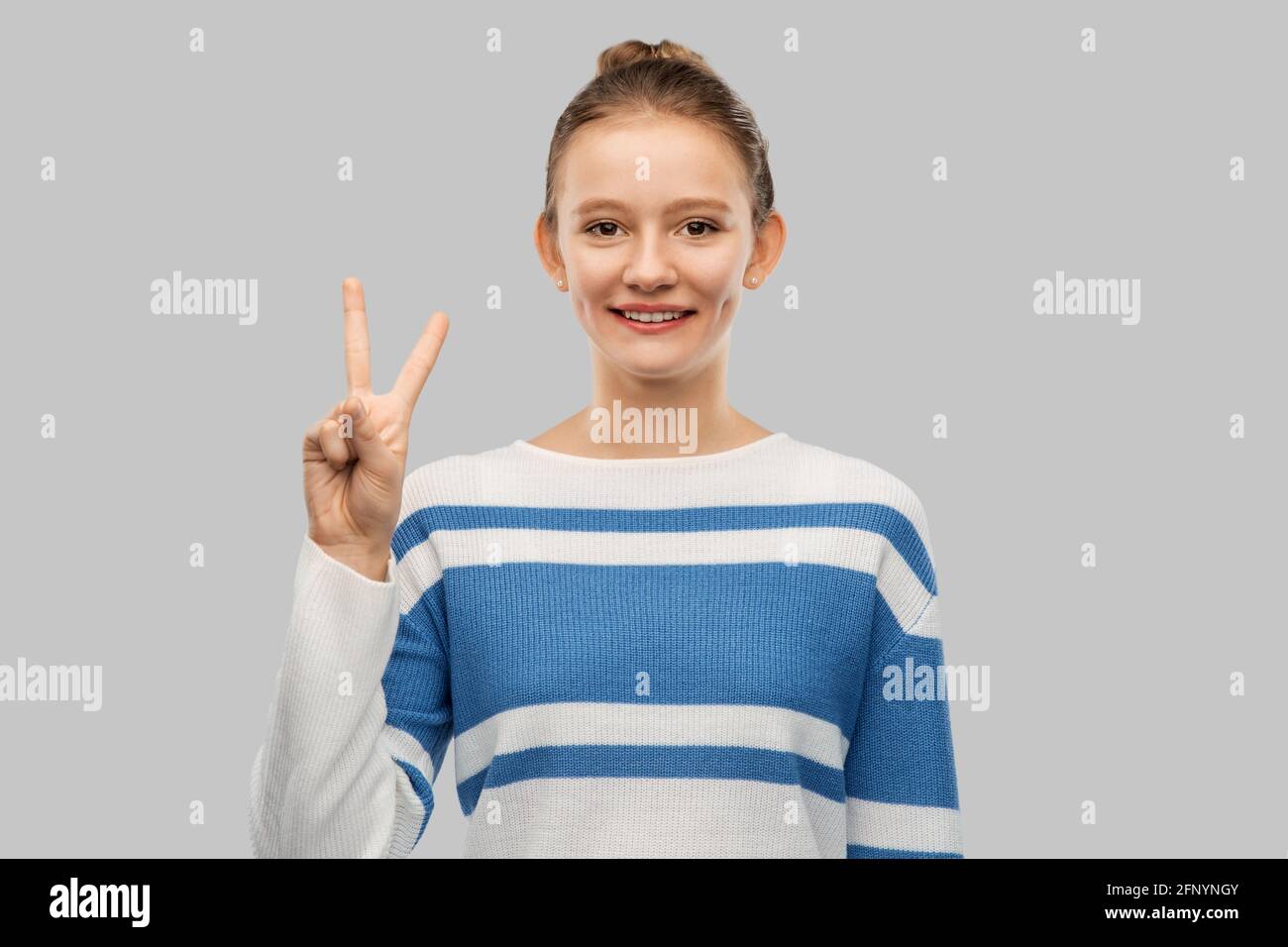 smiling teenage girl showing peace hand sign Stock Photo - Alamy