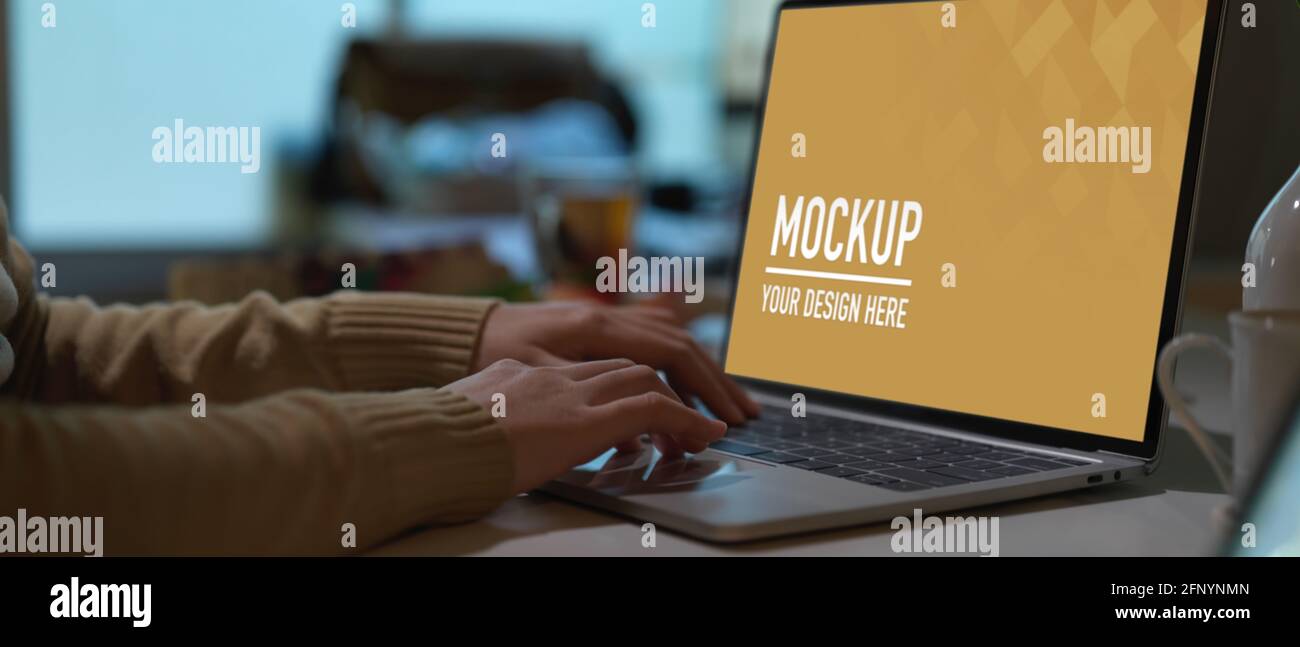 Side view of hands typing on laptop keyboard in home office room ...