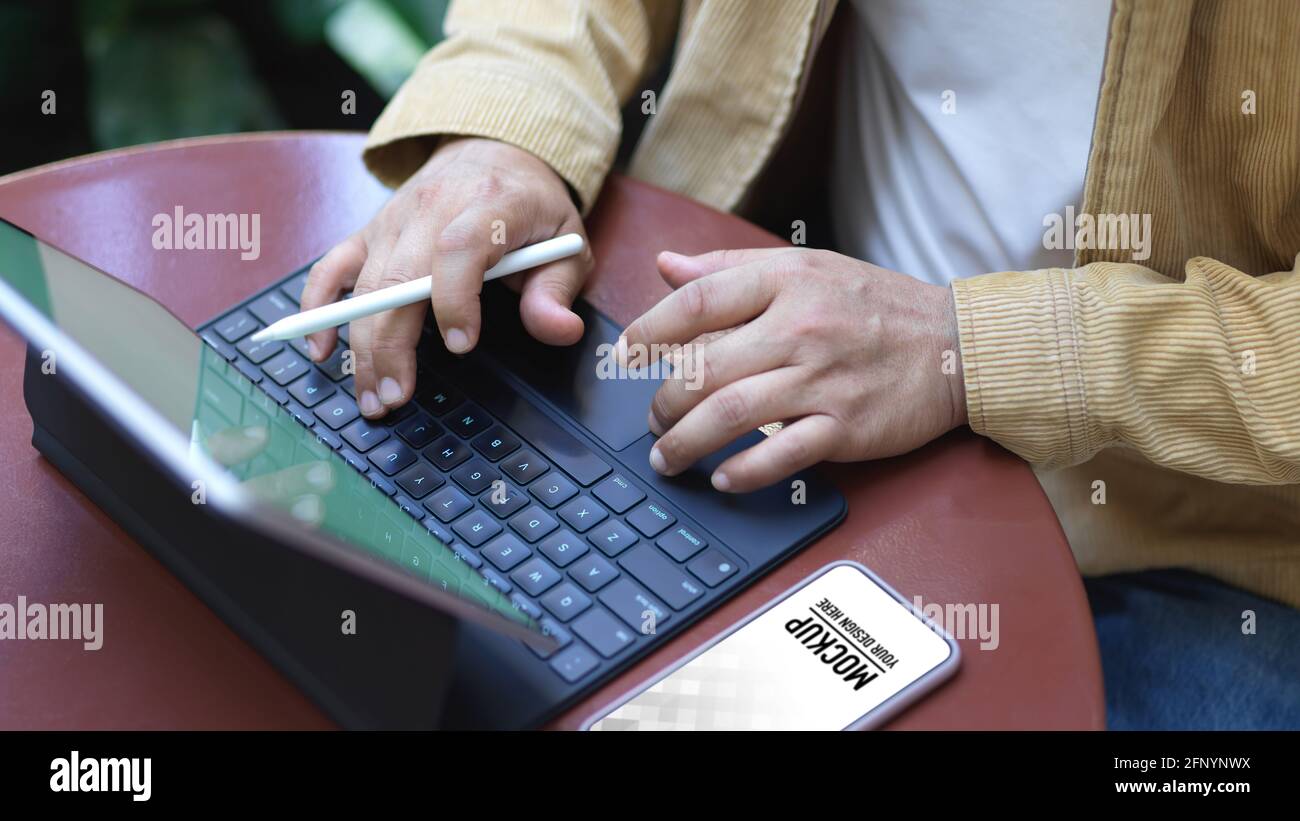 Close up view of male hands typing pen tablet keyboard on coffee table ...