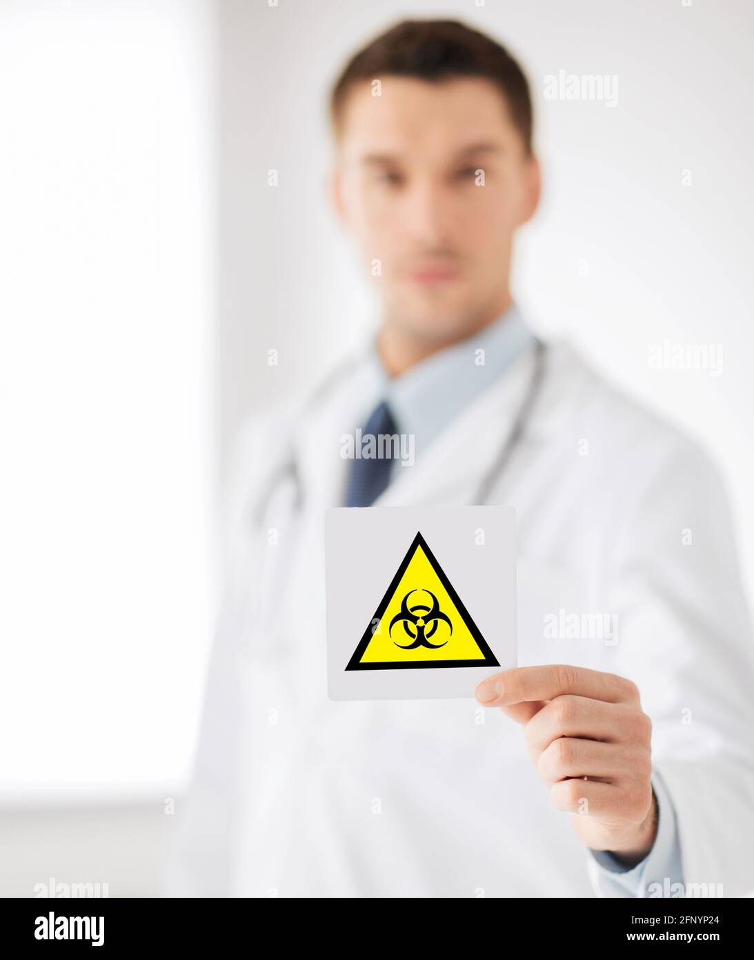male doctor holding boihazard caution sign Stock Photo - Alamy