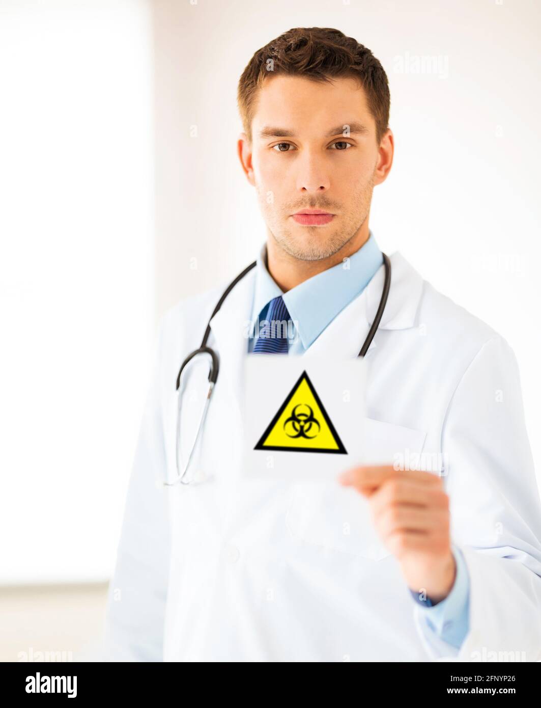 male doctor holding boihazard caution sign Stock Photo - Alamy