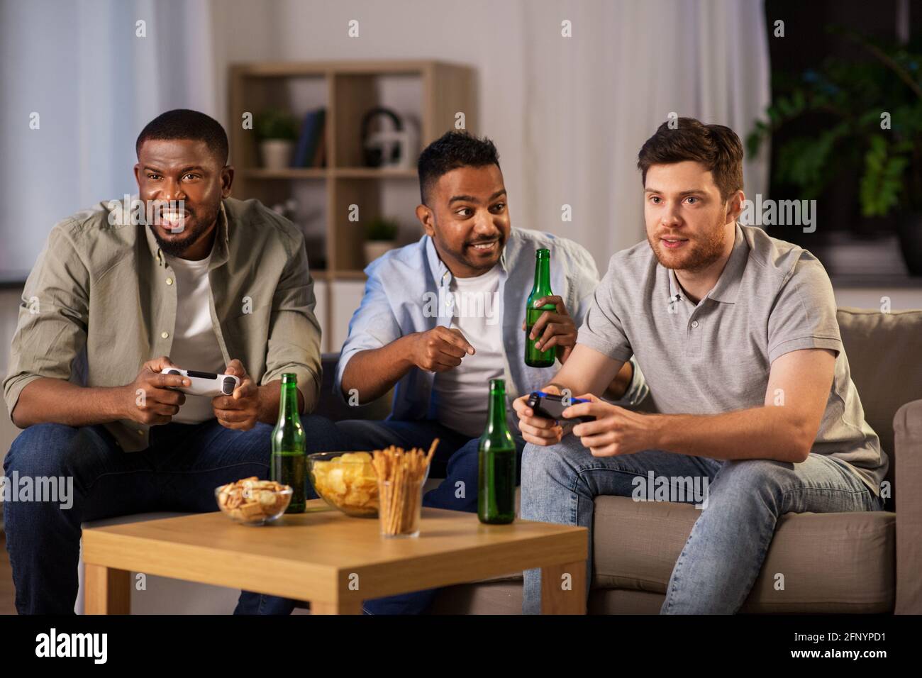 happy friends playing video games at home at night Stock Photo - Alamy