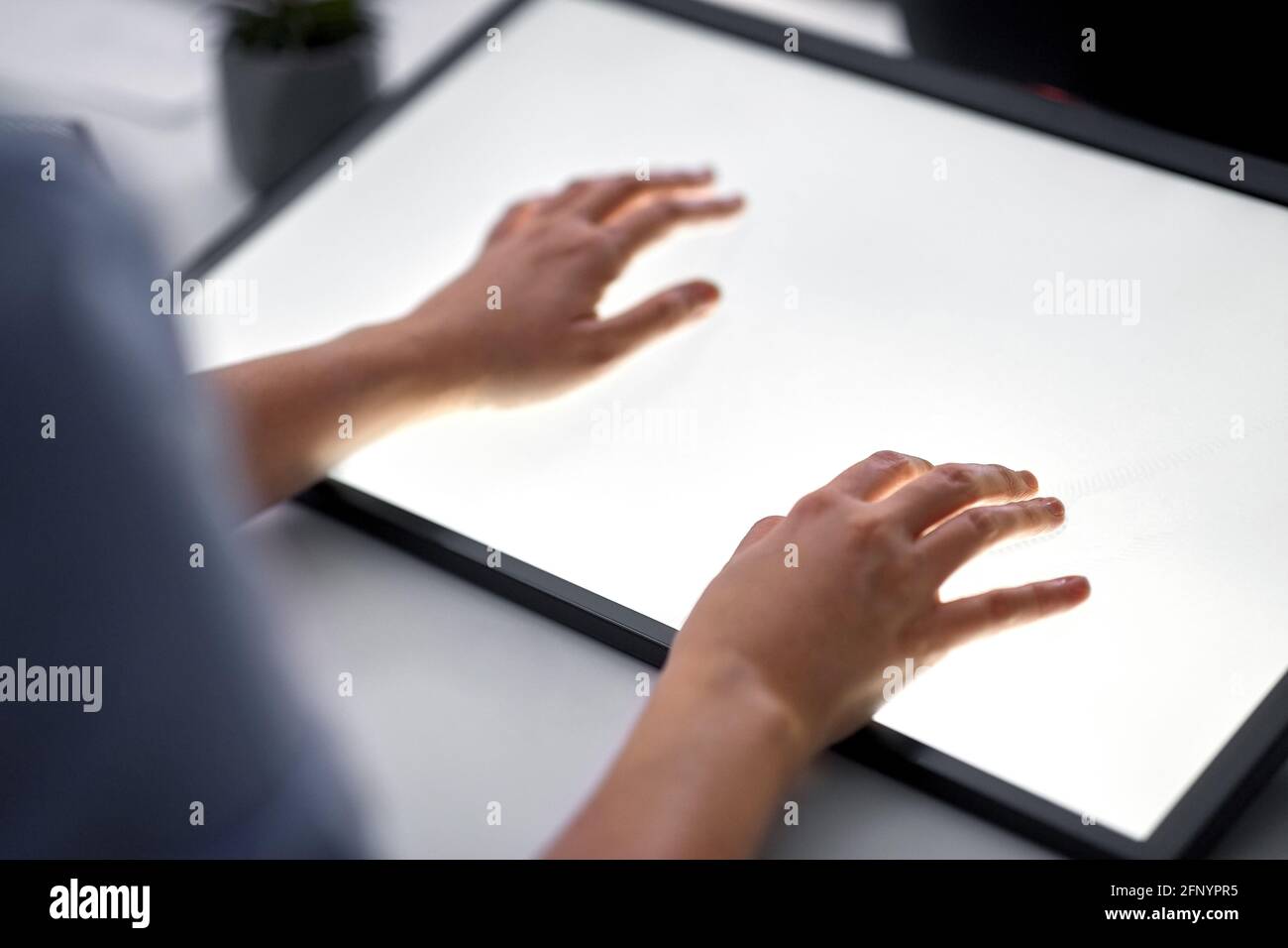 hands on led light tablet at night office Stock Photo - Alamy