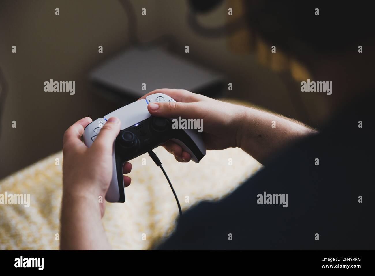 YORK, UK - MAY 9, 2021. Close up of a teenage boy holding a PS5 gaming ...