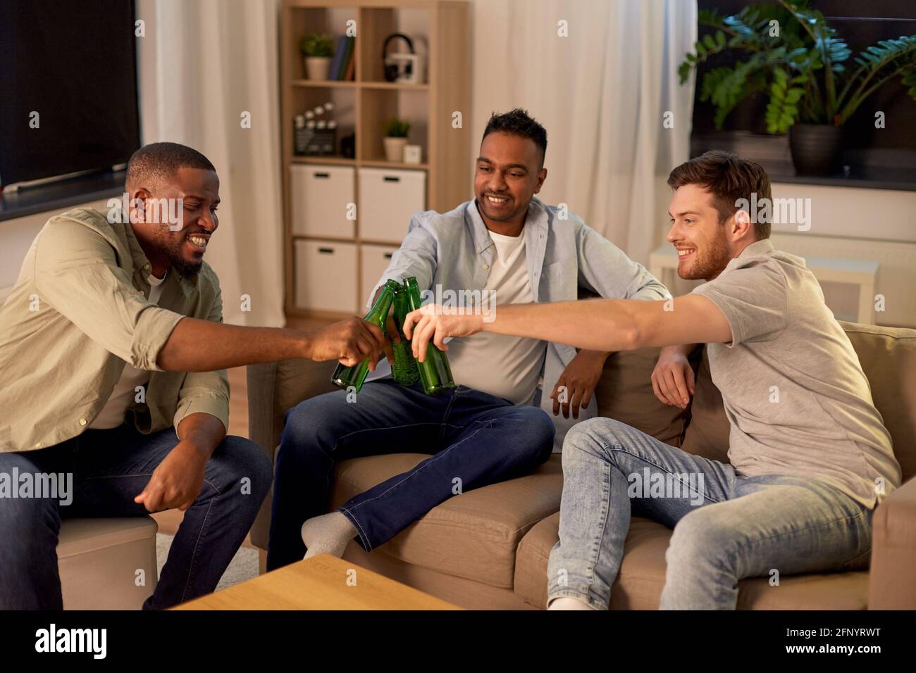 happy male friends drinking beer at home at night Stock Photo - Alamy