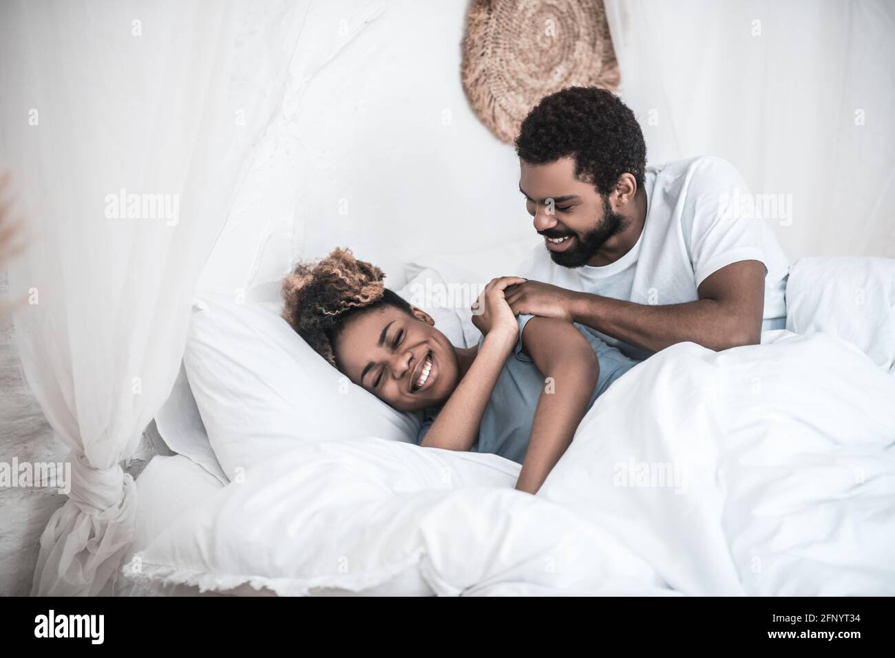 Man touching shoulder of sleeping wife Stock Photo - Alamy