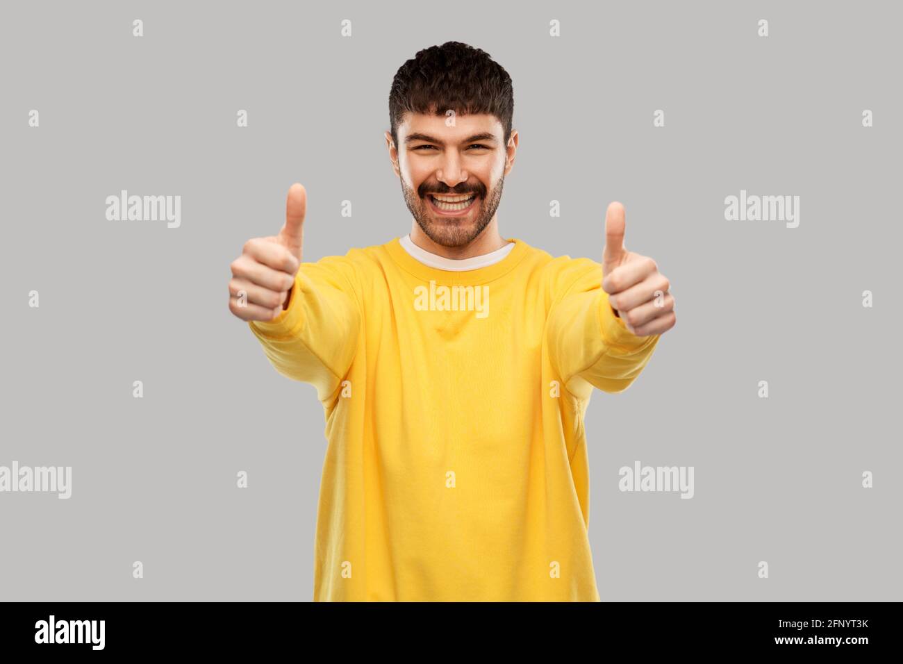 smiling young man showing thumbs up Stock Photo - Alamy