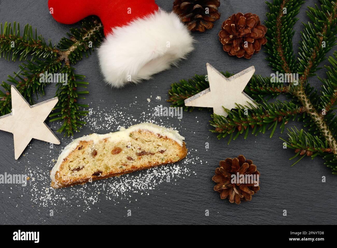 christmas stollen with fir branch, santa claus shoe and stars lying on ...