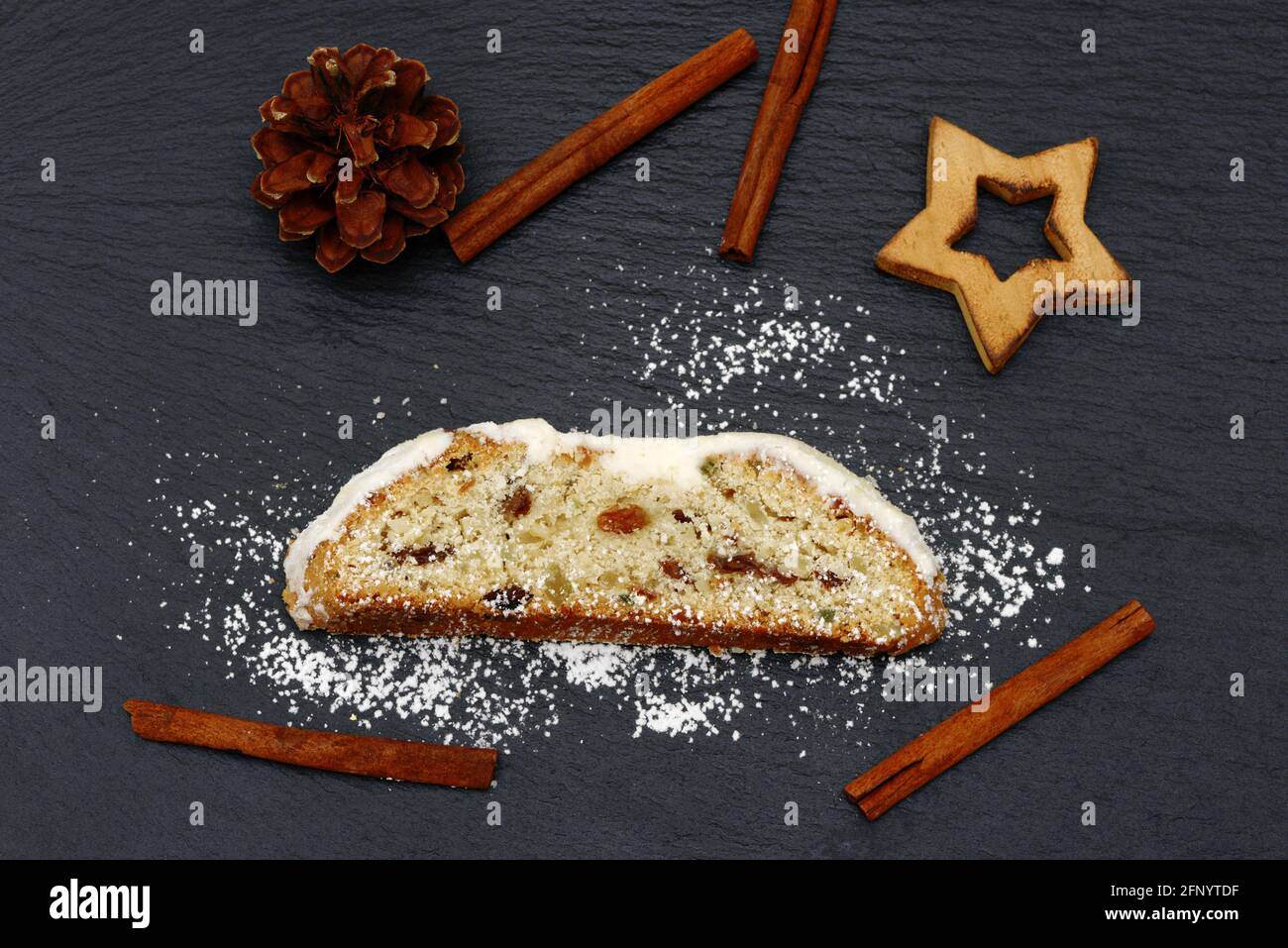 christmas stollen with pine cone, stars and cinnemon sticks lying on ...