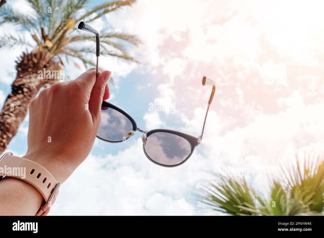 Womans hand holding sunglasses close-up Stock Photo - Alamy
