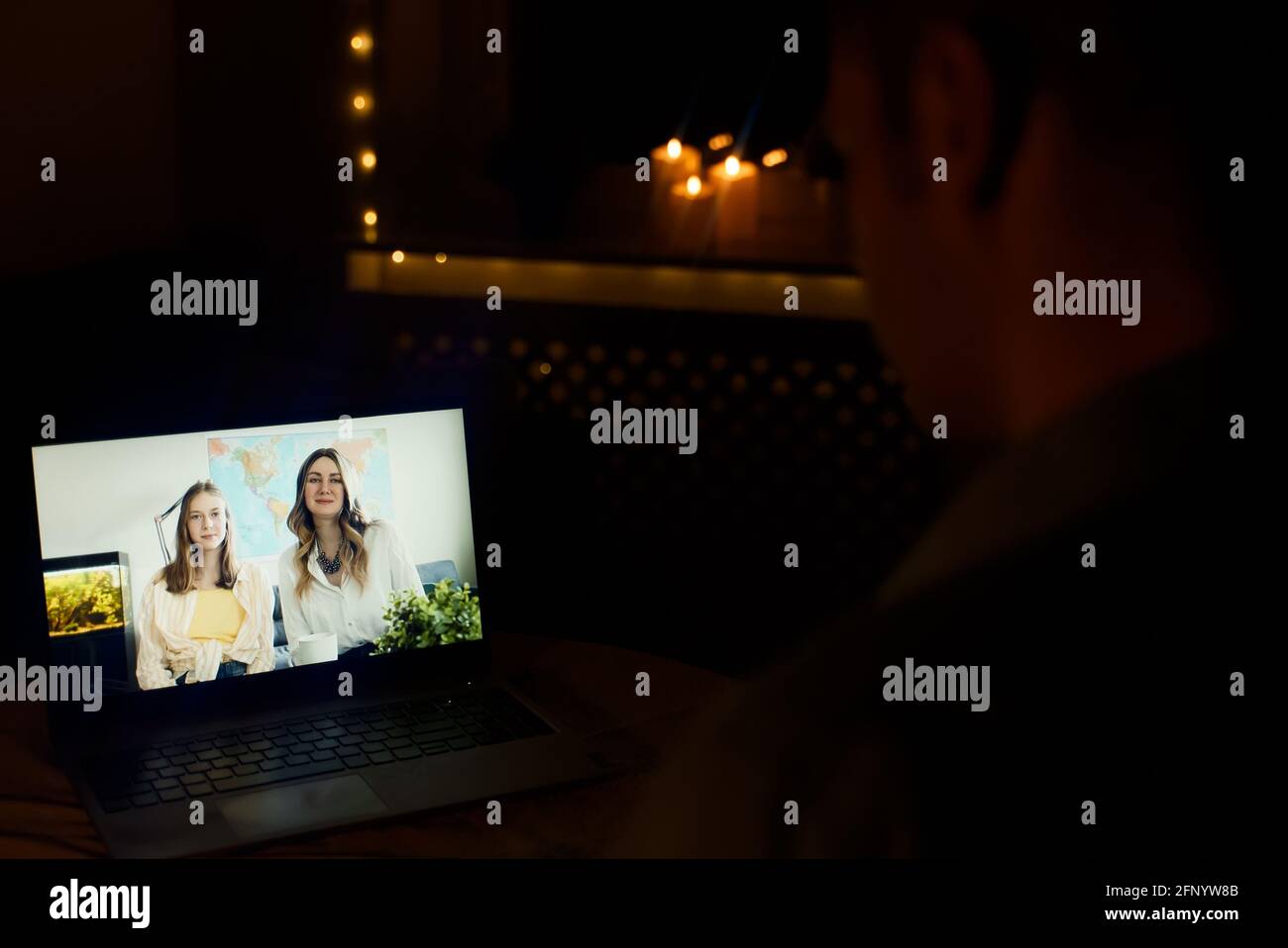 Man talking with his family in video chat at night. Time differences ...