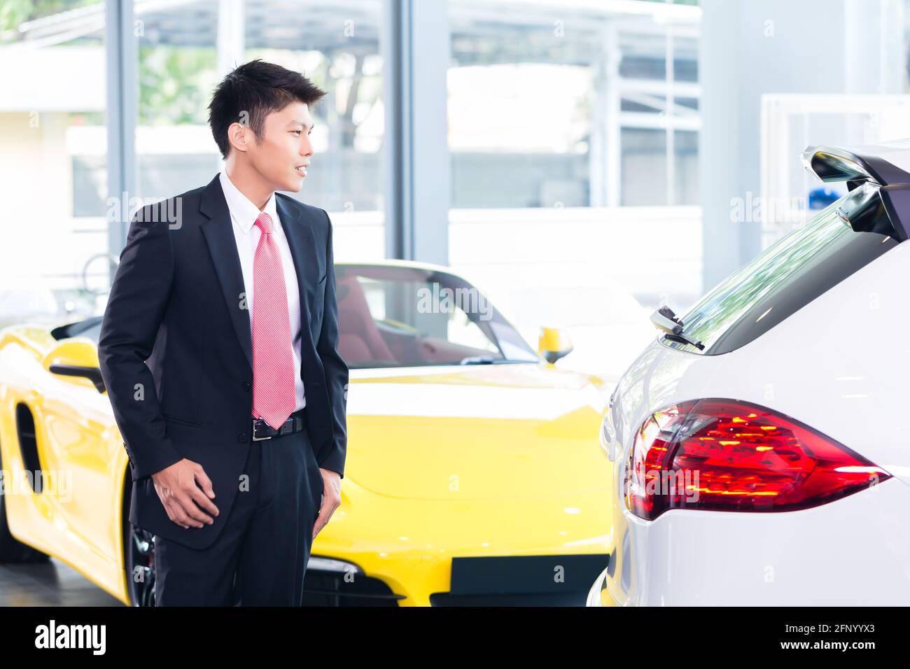 Chinese man buying luxury car in dealership Stock Photo - Alamy