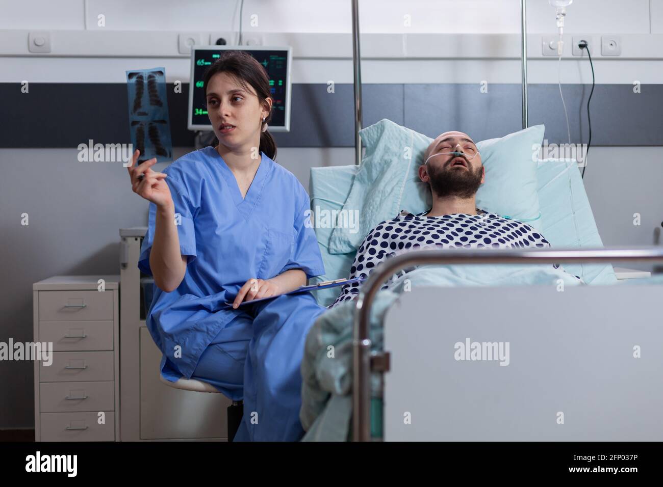 Close up of woman asisstant showing bones radiography to patient ...