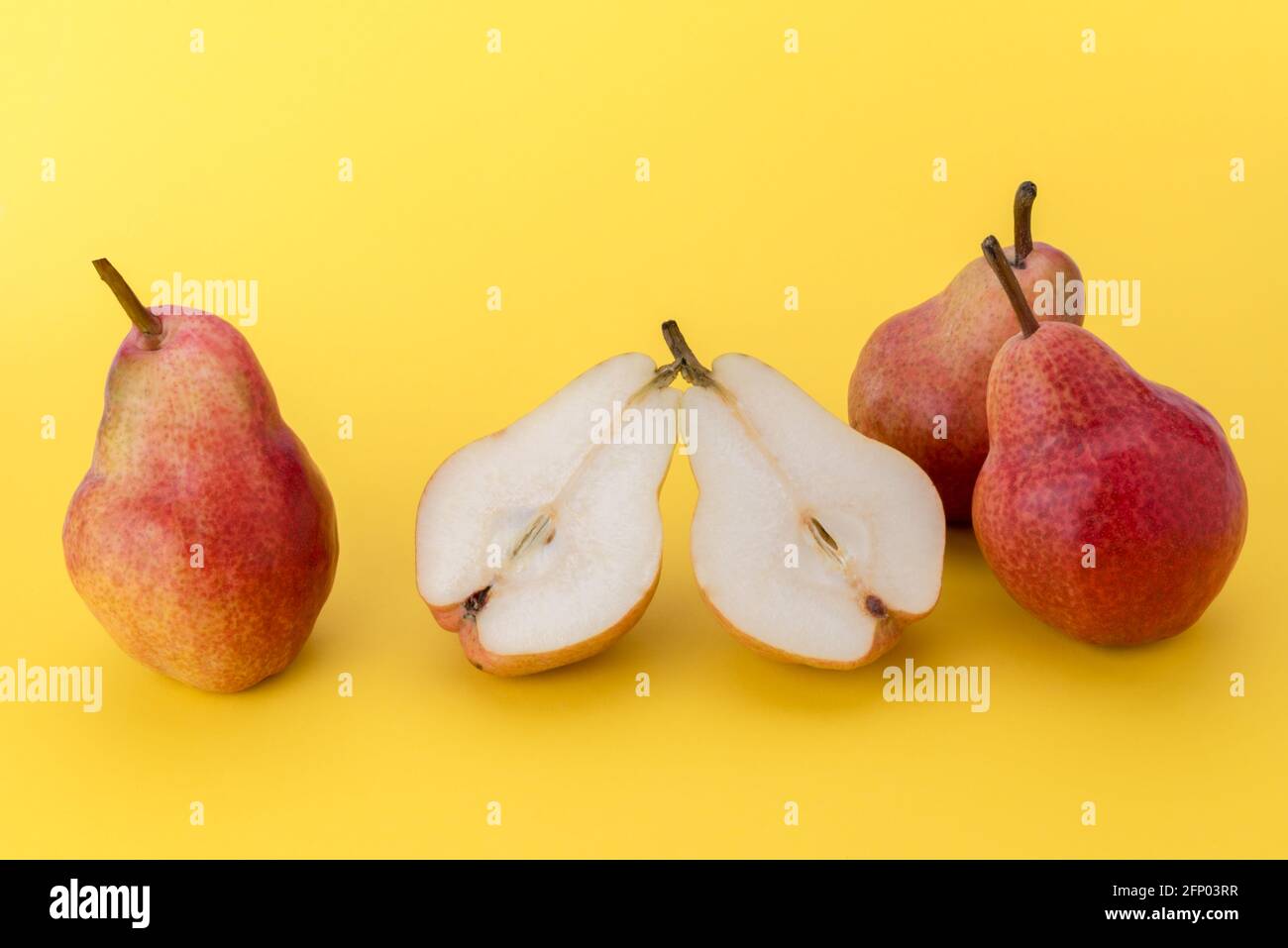 William Max Red Bartlett pear, three whole pears and one cut in half ...
