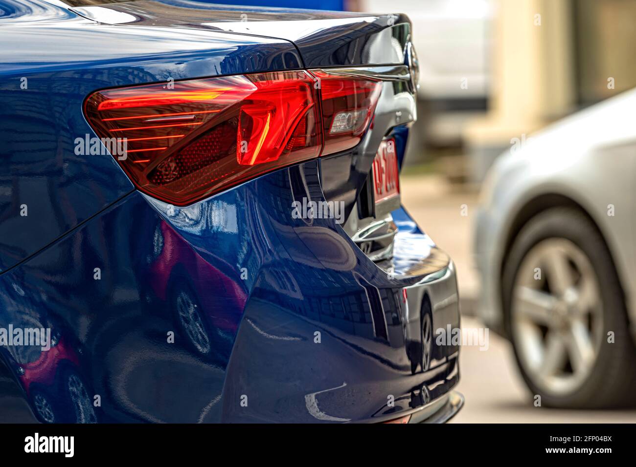 rear half with rear lights of a parked car on the side of the street ...