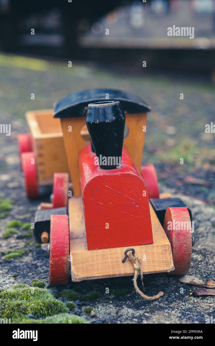 close-up of small wooden toy train with big train in the background ...