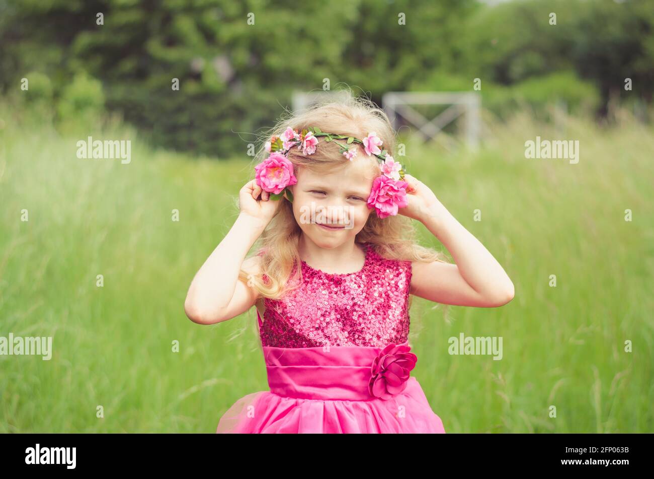 beautiful blond girl in pink dress holding two blossoming pink roses ...
