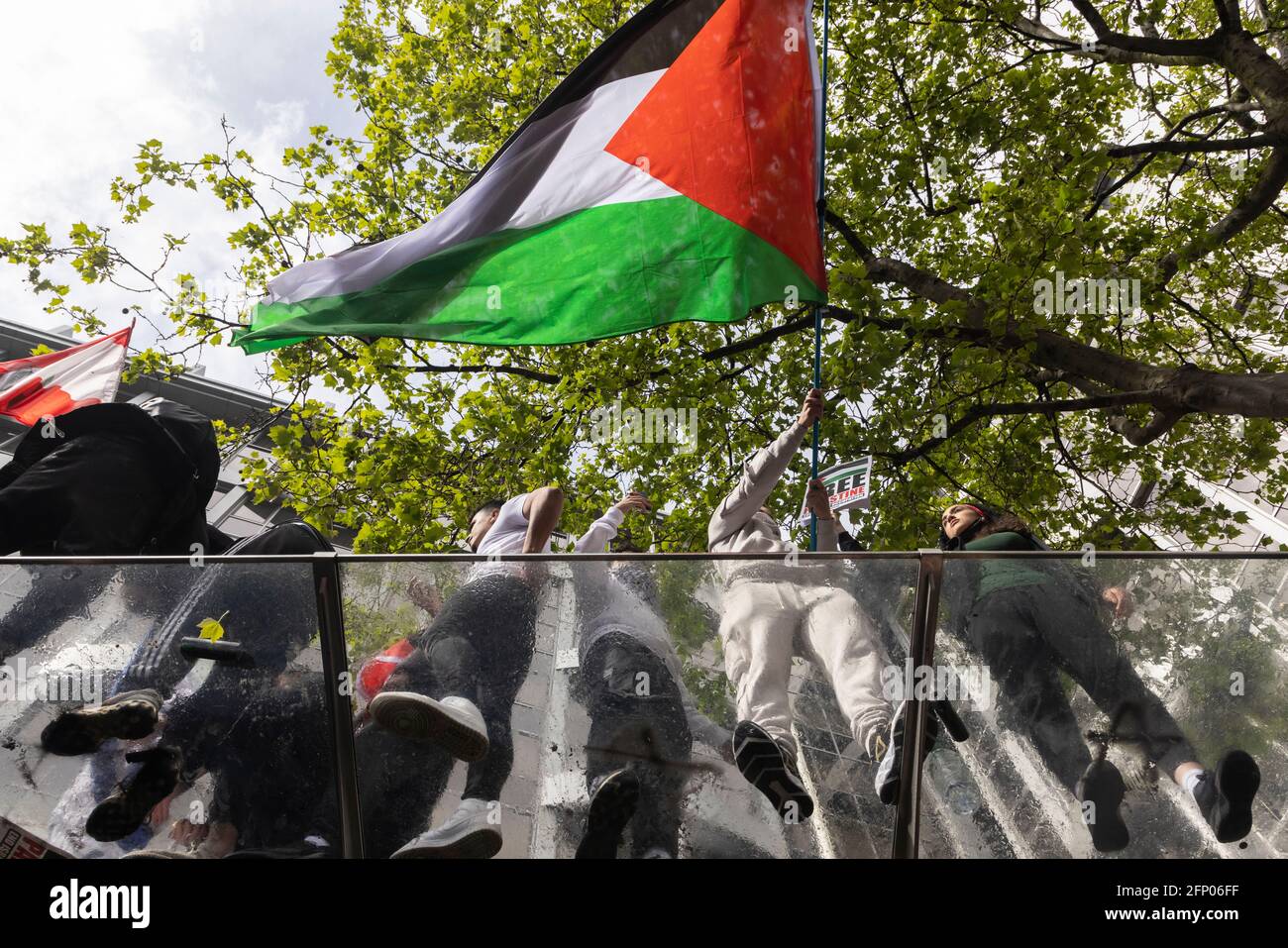 Protesters wave Palestinian flag from roof of bus shelter, 'Free ...