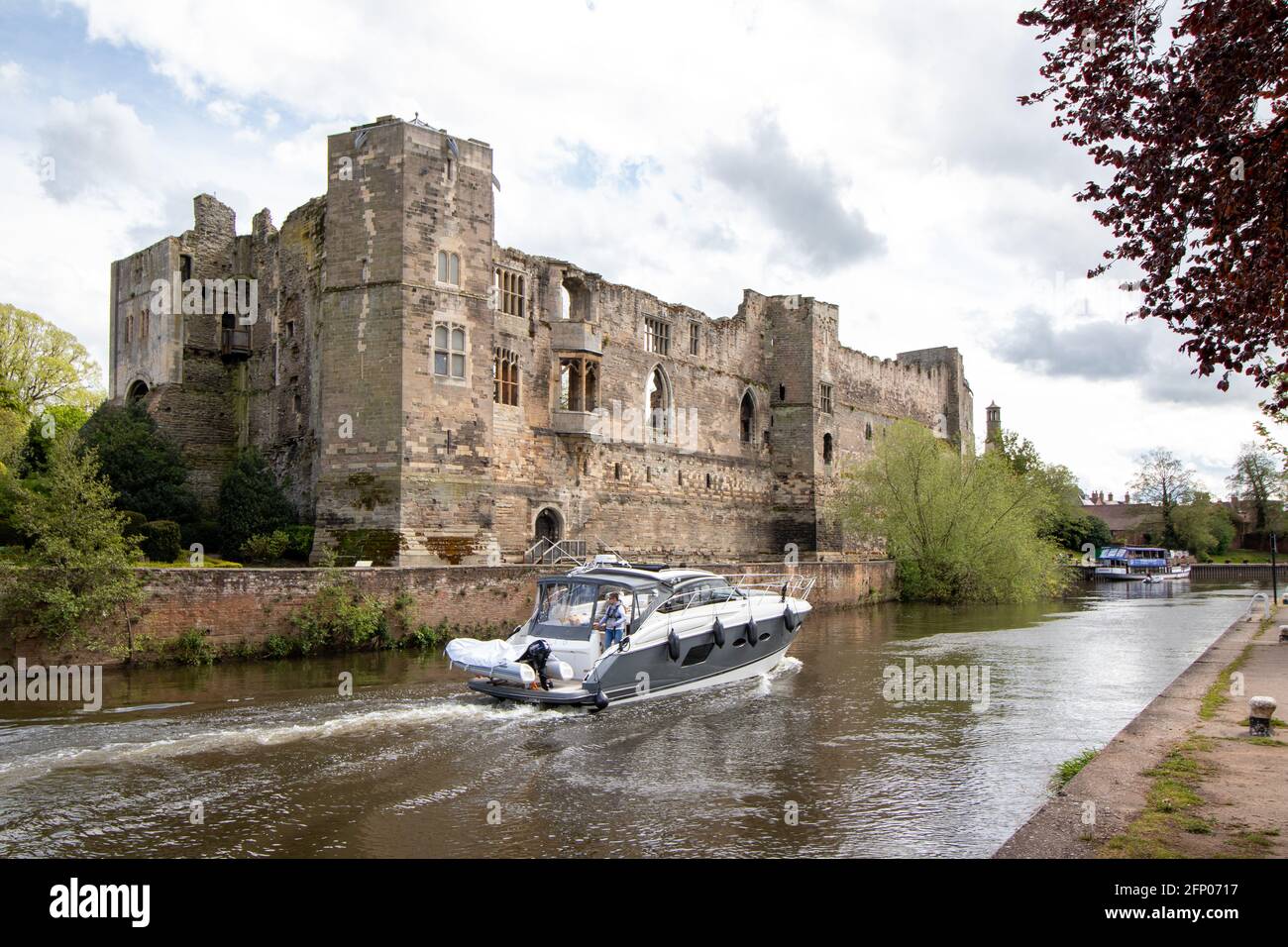 A modern motor boat travelling along the river Trent passes by Newark ...