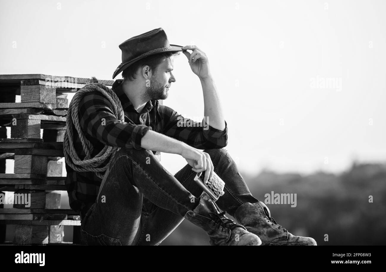 Watching sunset. Farmer cowboy handsome man relaxing after hard working ...