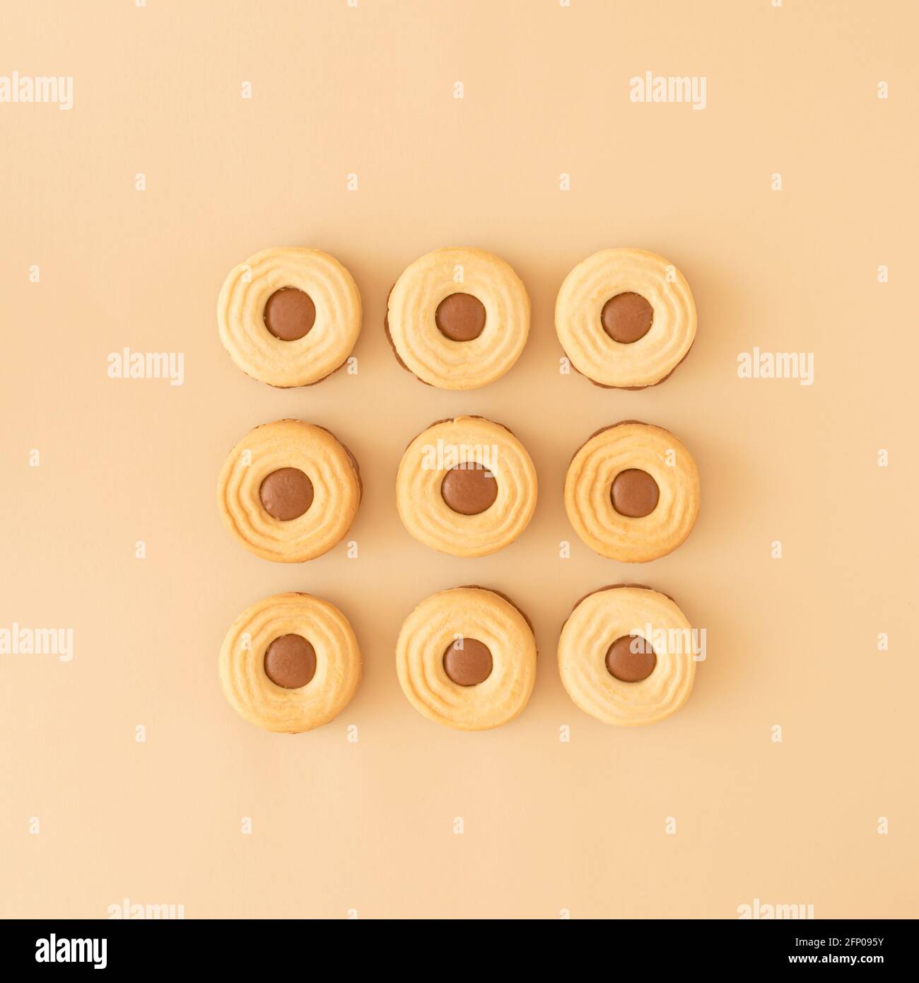 Chocolate cookies arranged in a cube on a cream background. Sweet food ...