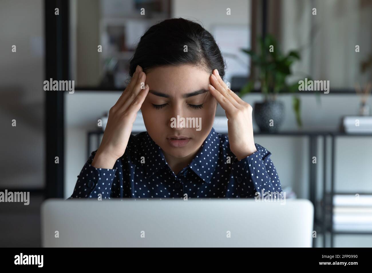 Unwell Indian female employee suffer form headache Stock Photo - Alamy