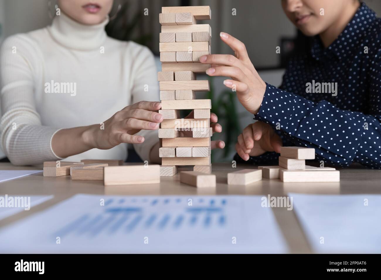 Close up of female colleagues engaged in teambuilding game activity ...