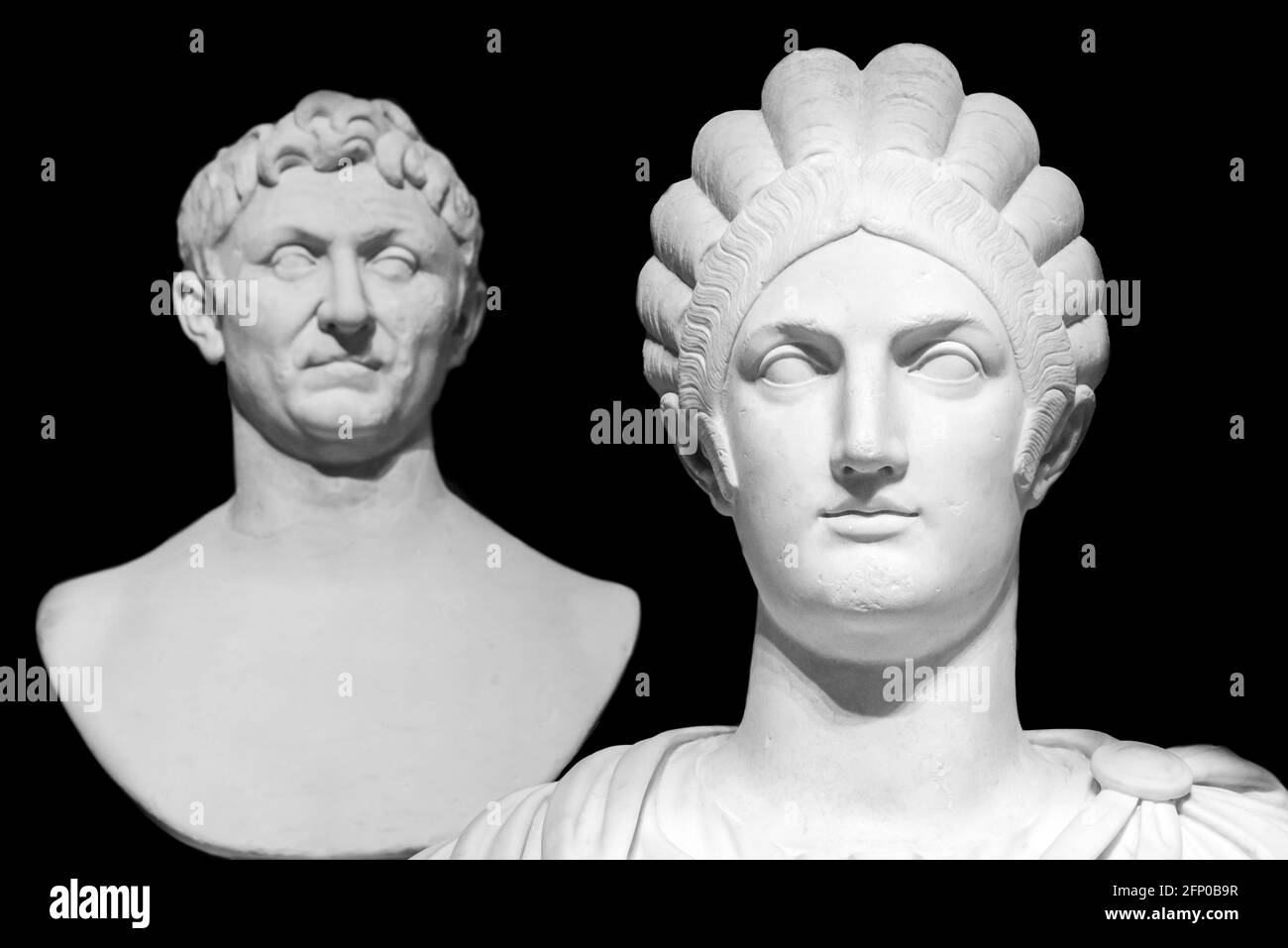 Black and white photo in close-up on faces of two ancient roman busts ...