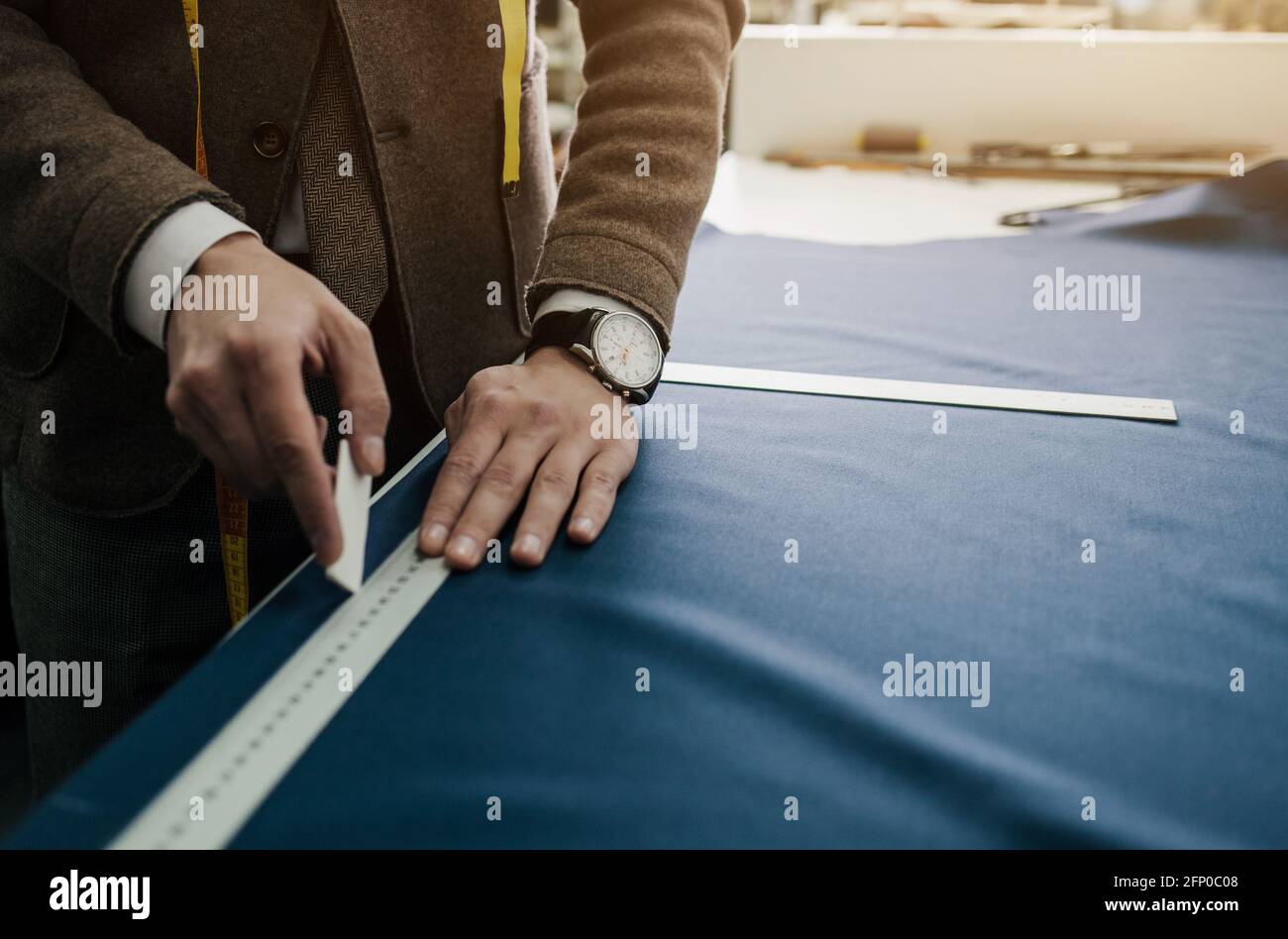 a fashion designer marks out a clothing cutting line. tailor in the ...