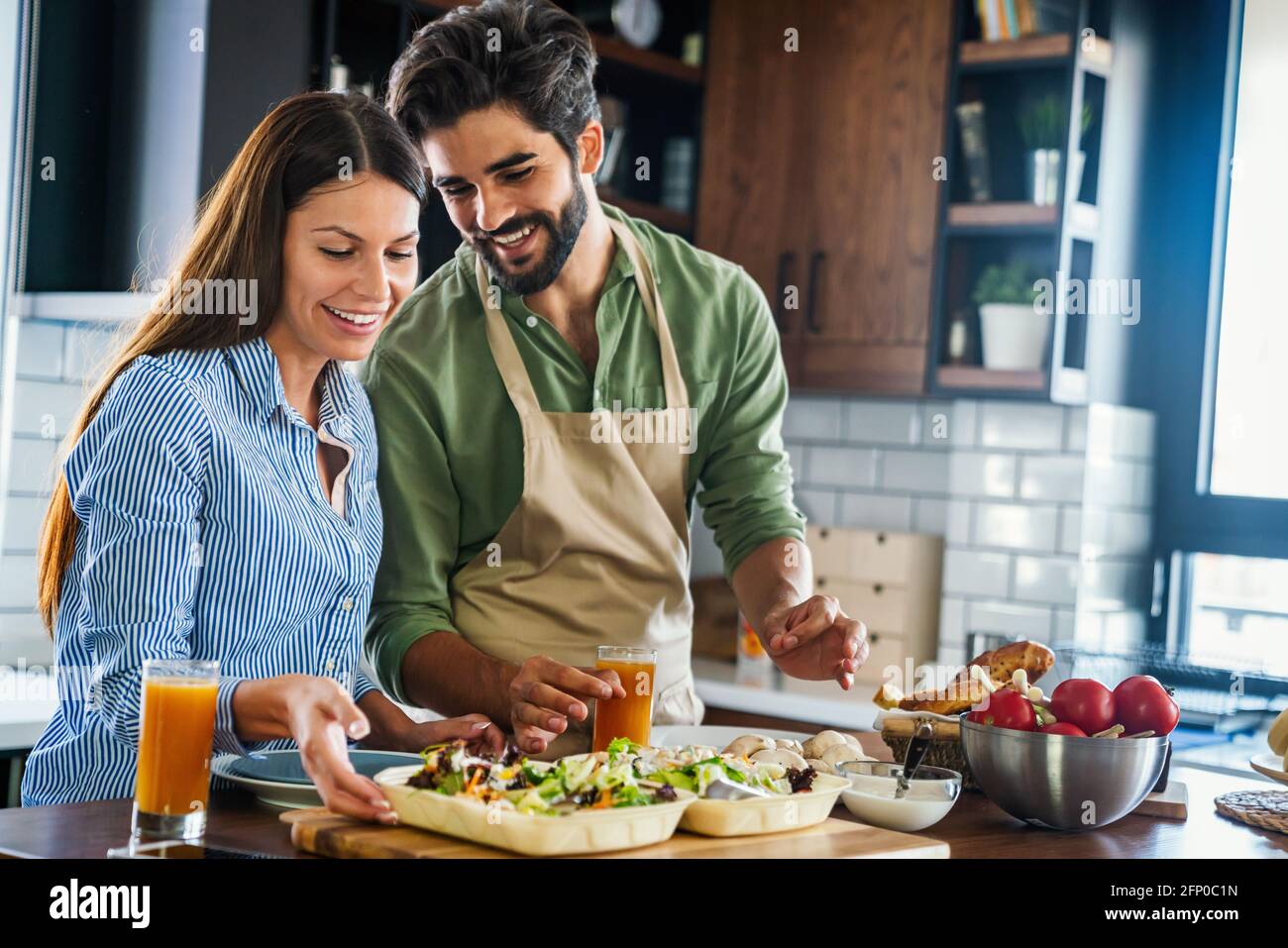 Portrait of happy couple cooking together in the kitchen at home Stock ...