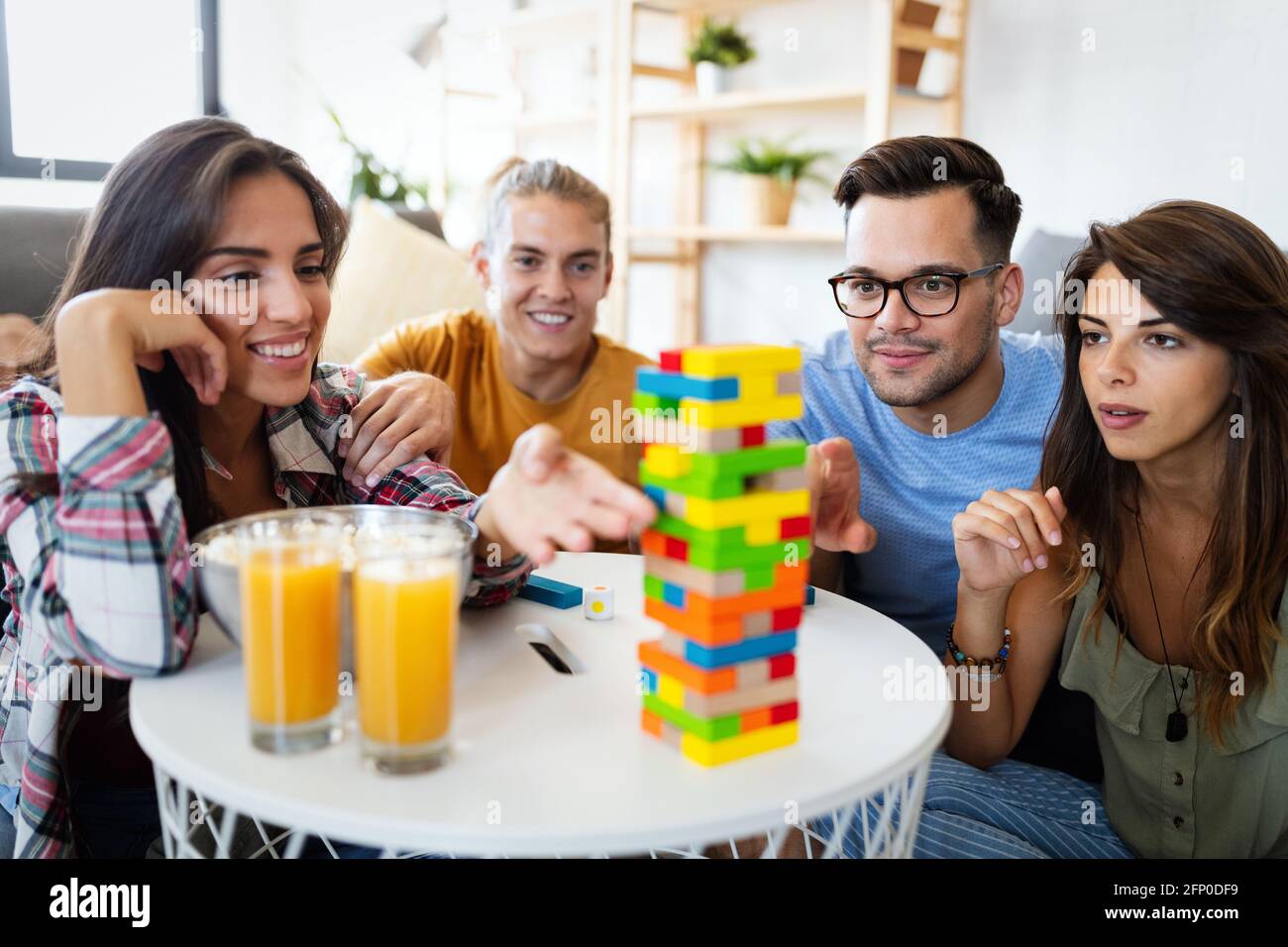 Group of young happy friends having fun playing wood board game Stock ...